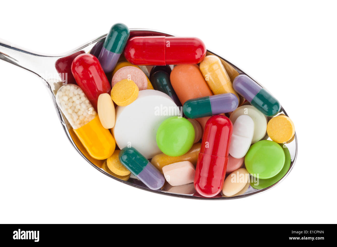Many different colored tablets on a spoon. Abuse of drugs. Isolated on ...