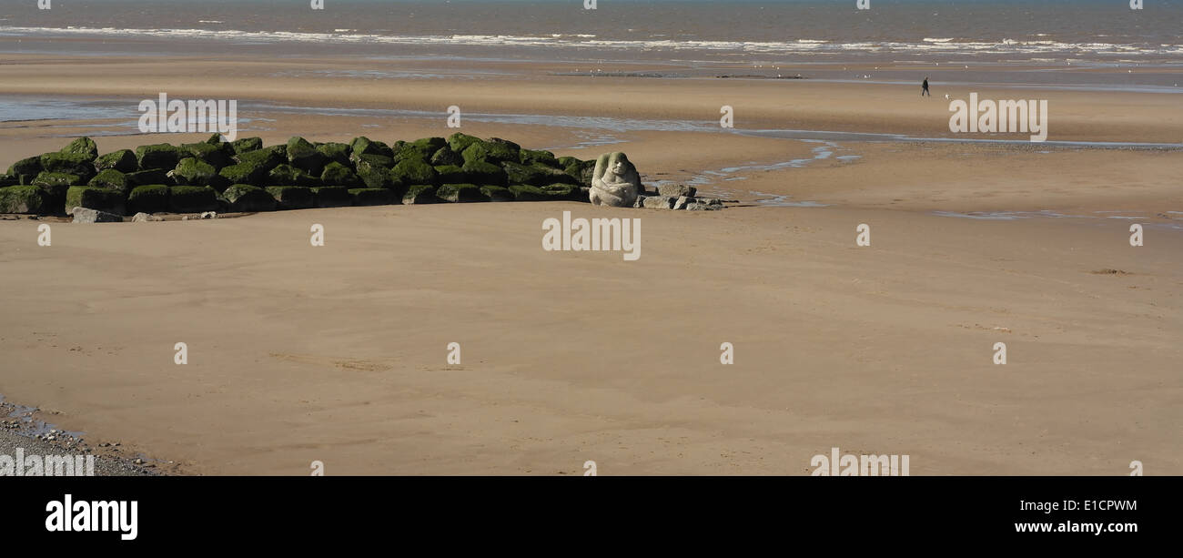 Sunny view from promenade, across low tide beach, stone Sea Ogre ...