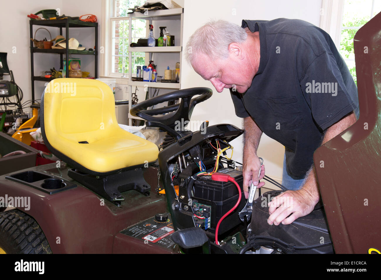 Man working on tractor engine in garage on a home Stock Photo - Alamy