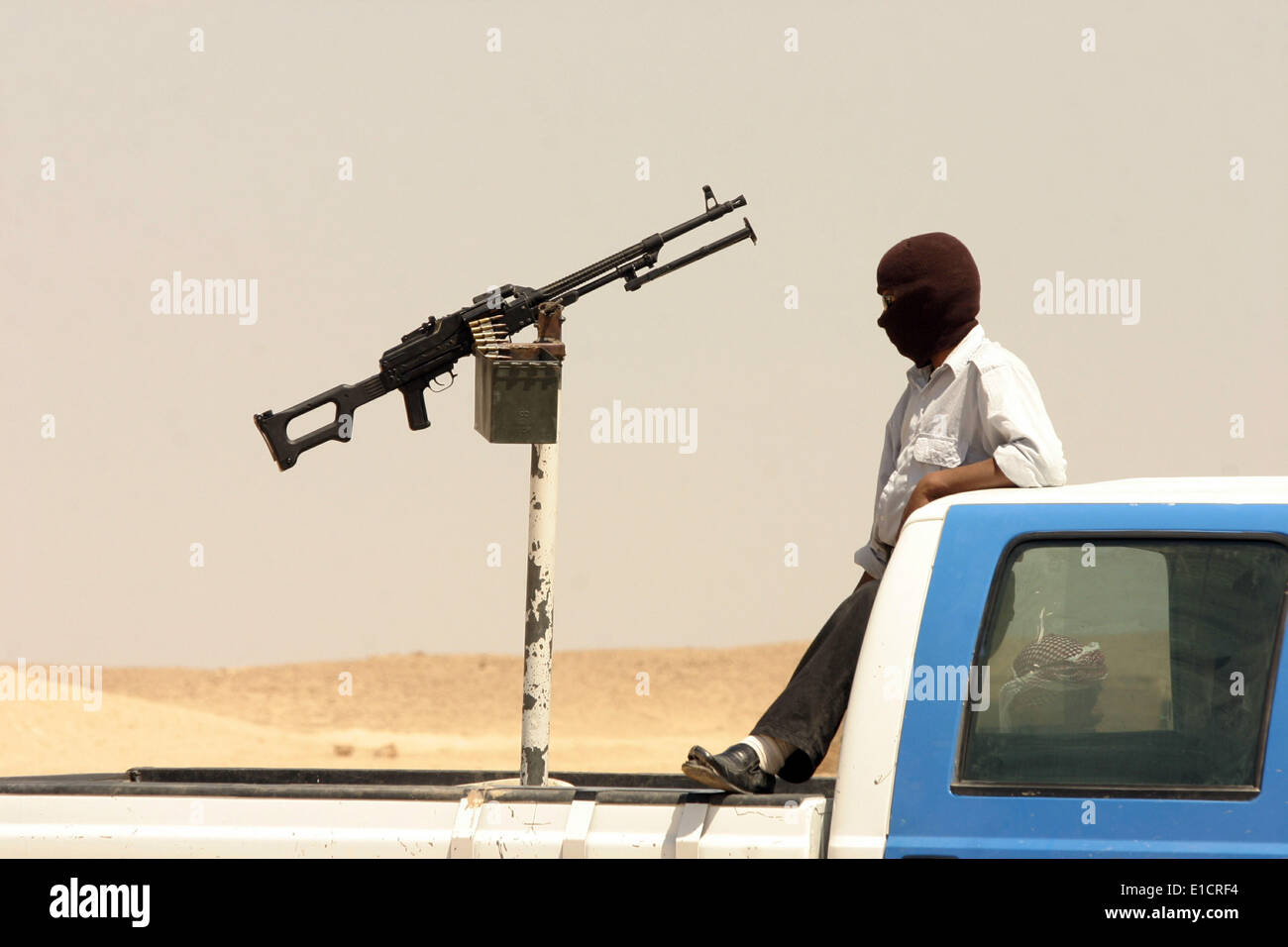 An Iraqi police officer mans a PKM machine gun position in the back of ...
