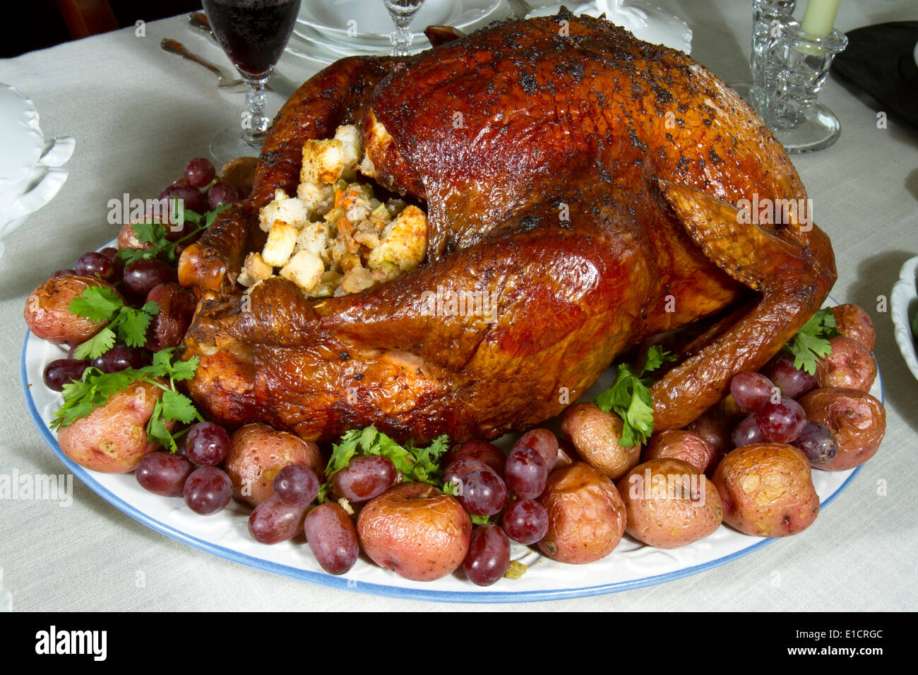 Holiday turkey filled with stuffing on a platter with potatoes and ...
