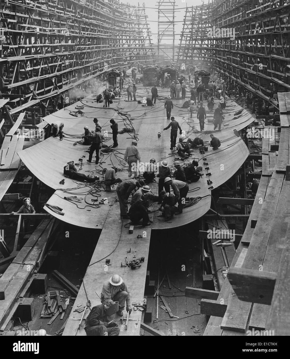 American war workers laying down the hull of a Liberty Ship. It was one ...