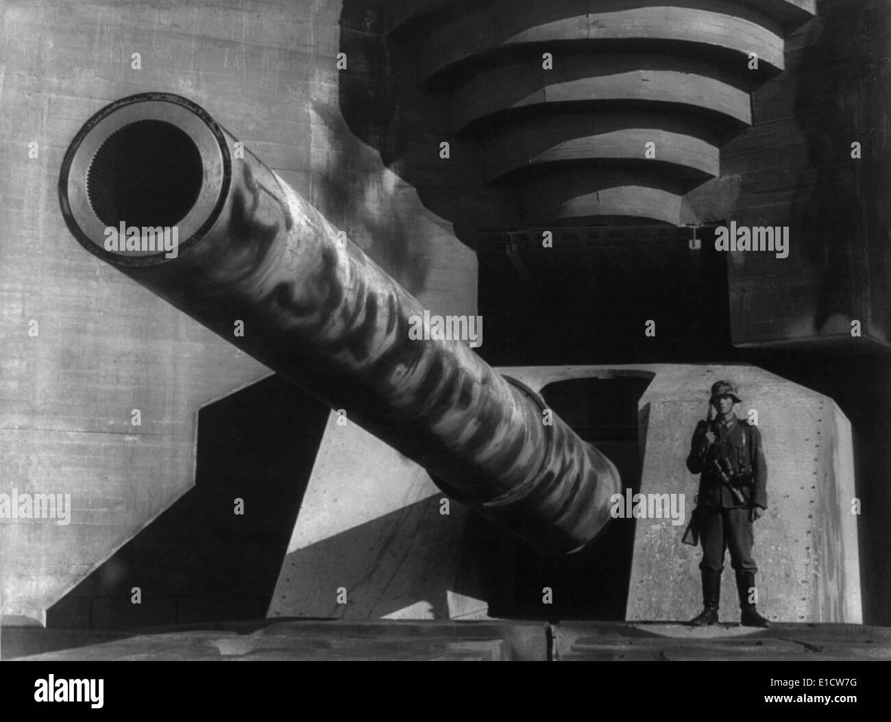 German soldier guards a large gun on the Atlantic Wall. 1943 during ...