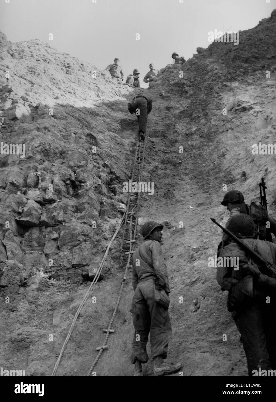 U.S. Rangers climb a cliff using a rope ladders at the Pointe du Hoc ...