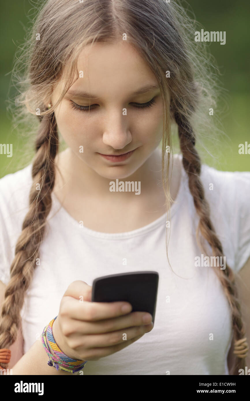 teen girl using mobile phone outdoors in park Stock Photo - Alamy
