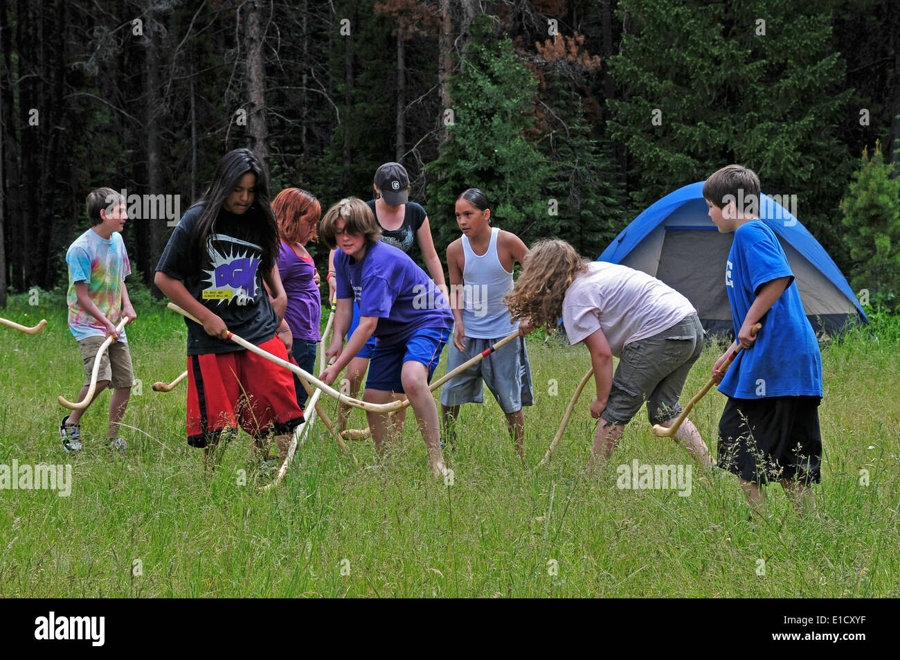 A traditional game of shinney is played outdoors, demonstrating ...