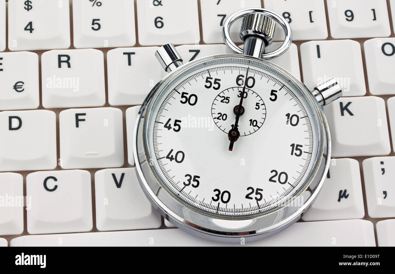 A stopwatch on a computer keyboard. Cost of labor Stock Photo - Alamy