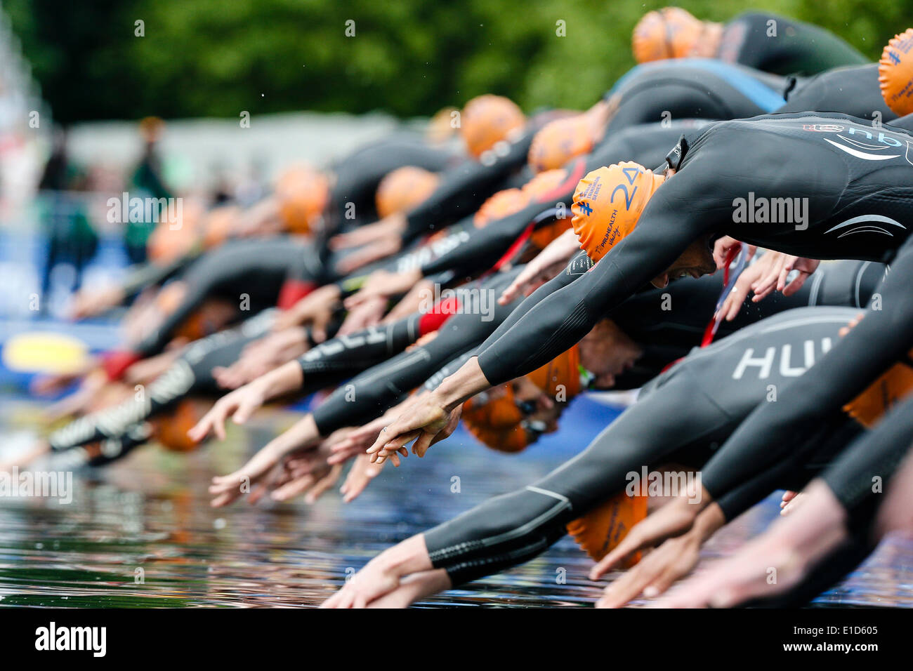 London, UK. 31st May, 2014. Competitors dive in at the mass start of ...