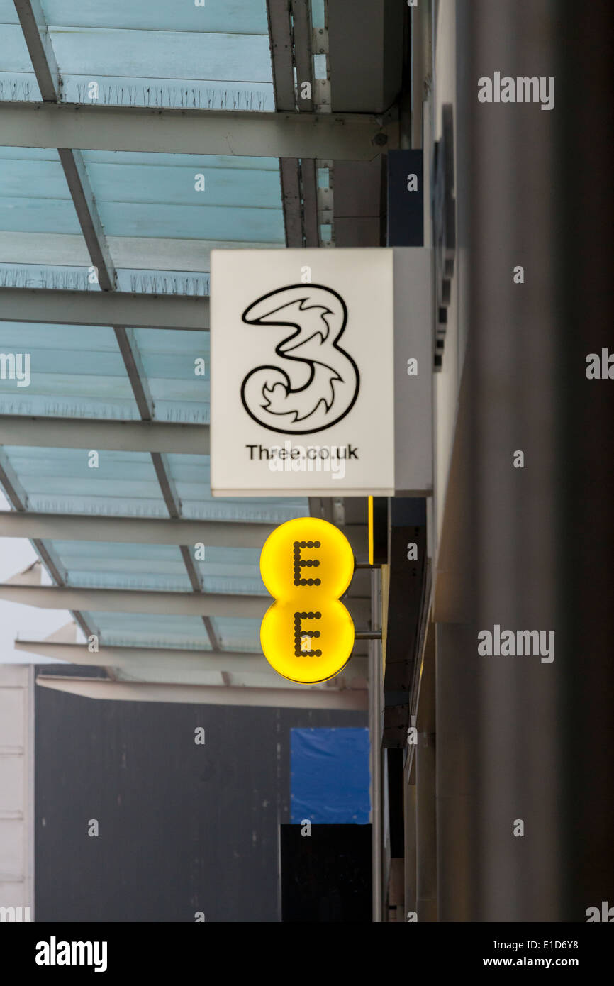 EE and Three mobile phone shop signs Stock Photo - Alamy