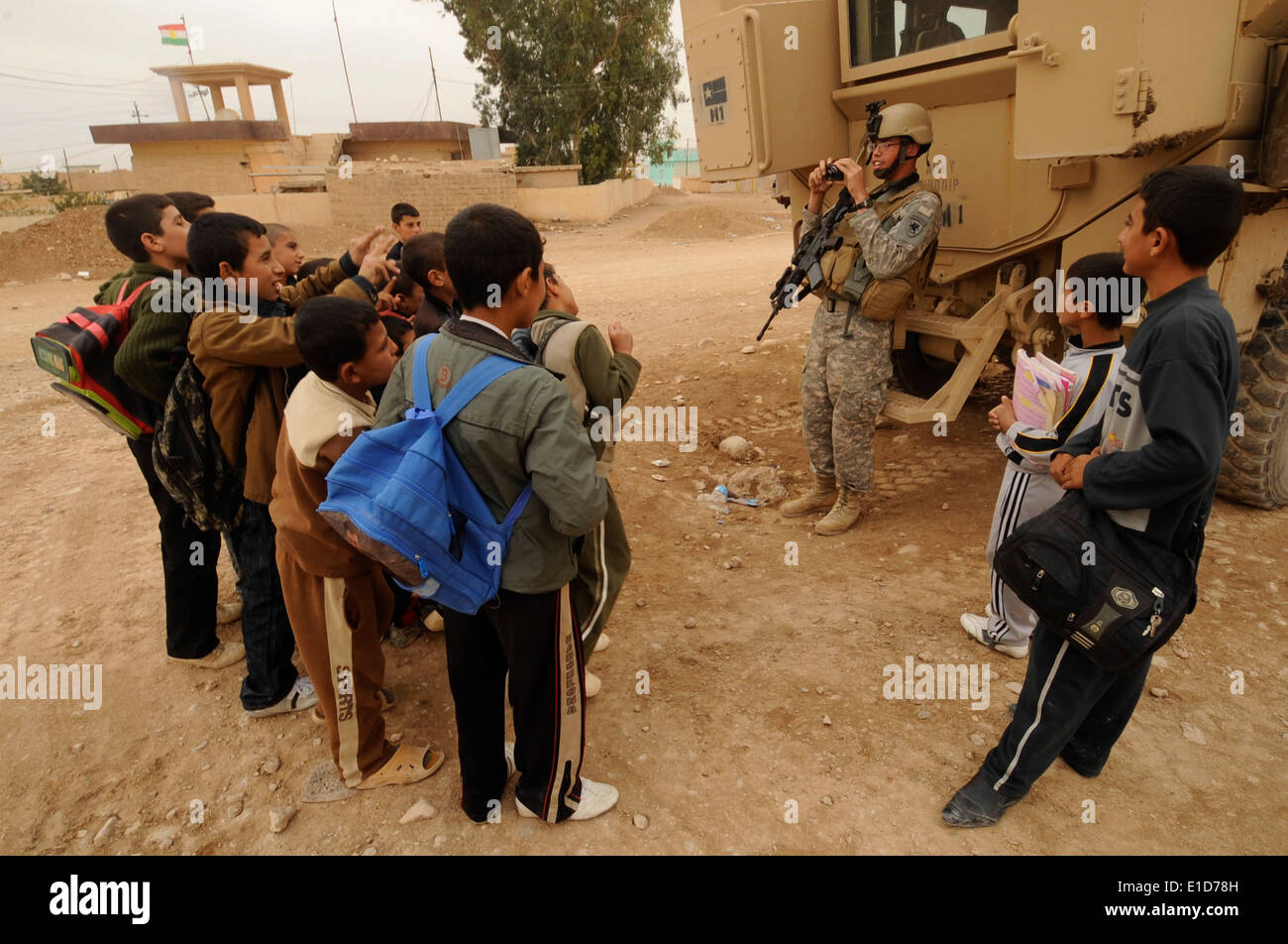 U.S. Army Pfc. Nathan Williams photographs a group of children in the ...