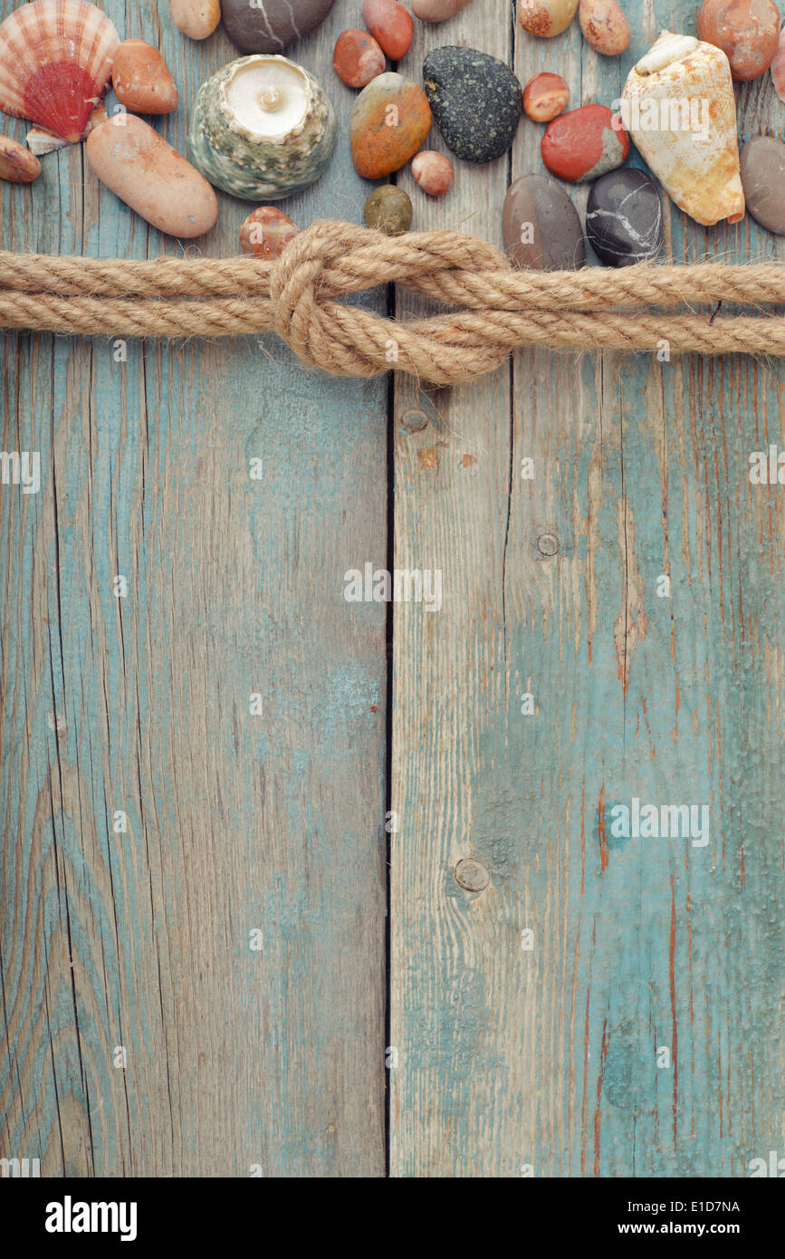 Sea shells and stones with rope on wooden background Stock Photo - Alamy