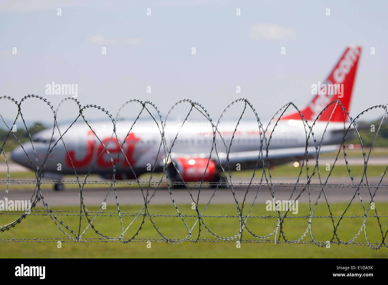 Jet 2 aircraft taxiing in front of barbed wire airport security fence ...