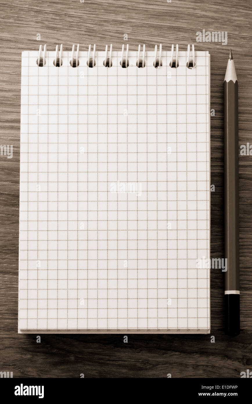 checked notebook on wood background Stock Photo - Alamy