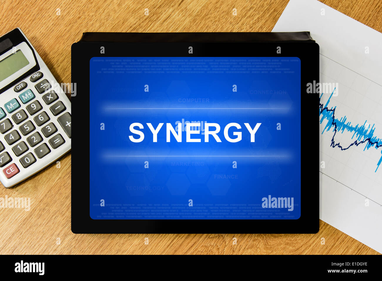 synergy word on digital tablet with calculator and financial graph ...