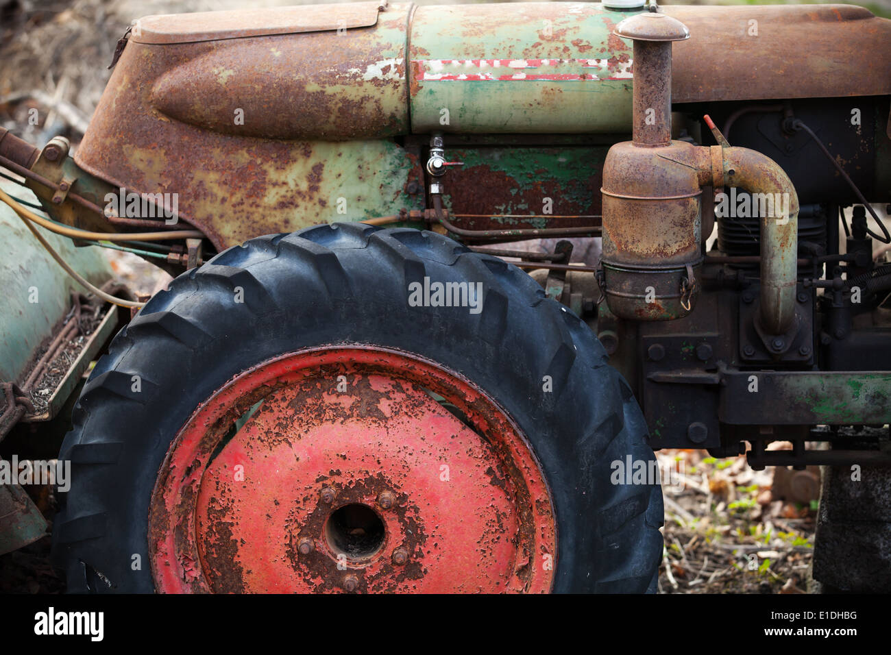 Fragment of old rusted green tractor with red wheel Stock Photo - Alamy