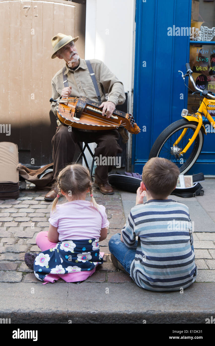 A busker at Rochester Sweeps Festival 2014 with two children looking at ...