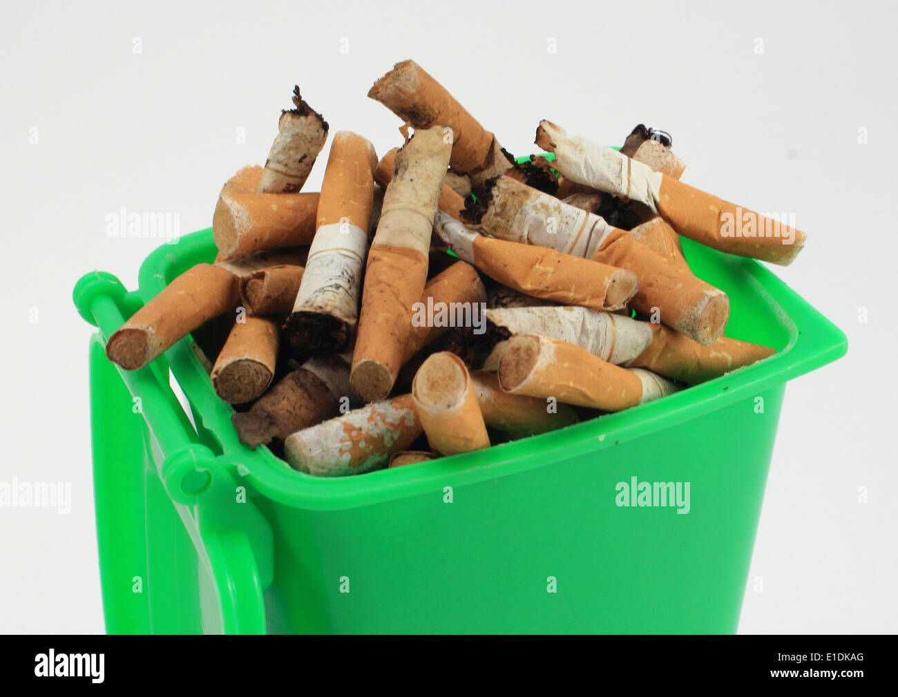 Used cigarette butts in green waste bin on white background Stock Photo ...