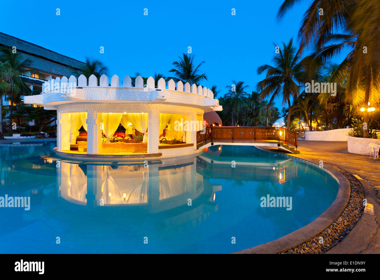 Illuminated pool and bar area at night Stock Photo - Alamy