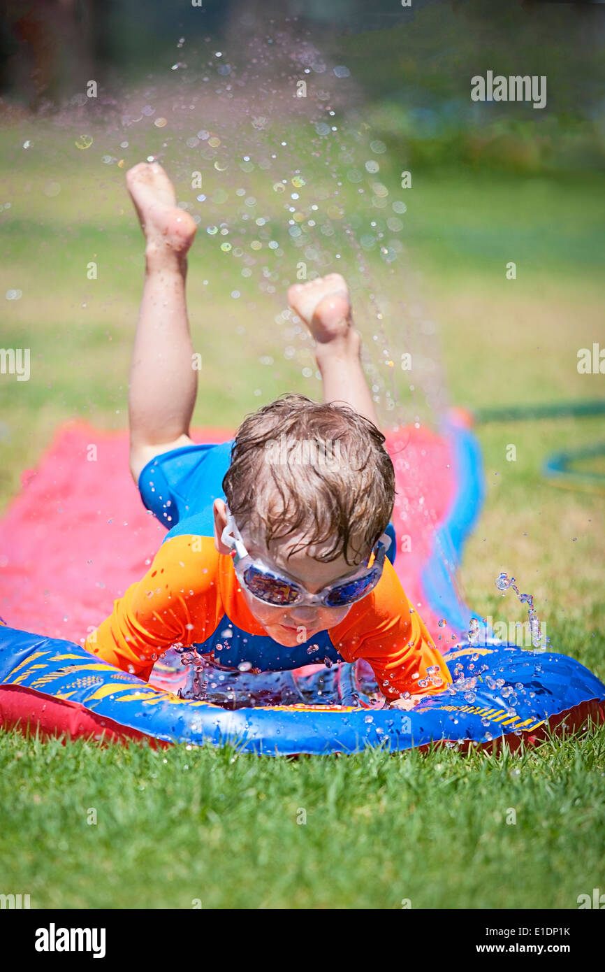 A young boy dives on a water slippy slide Stock Photo - Alamy