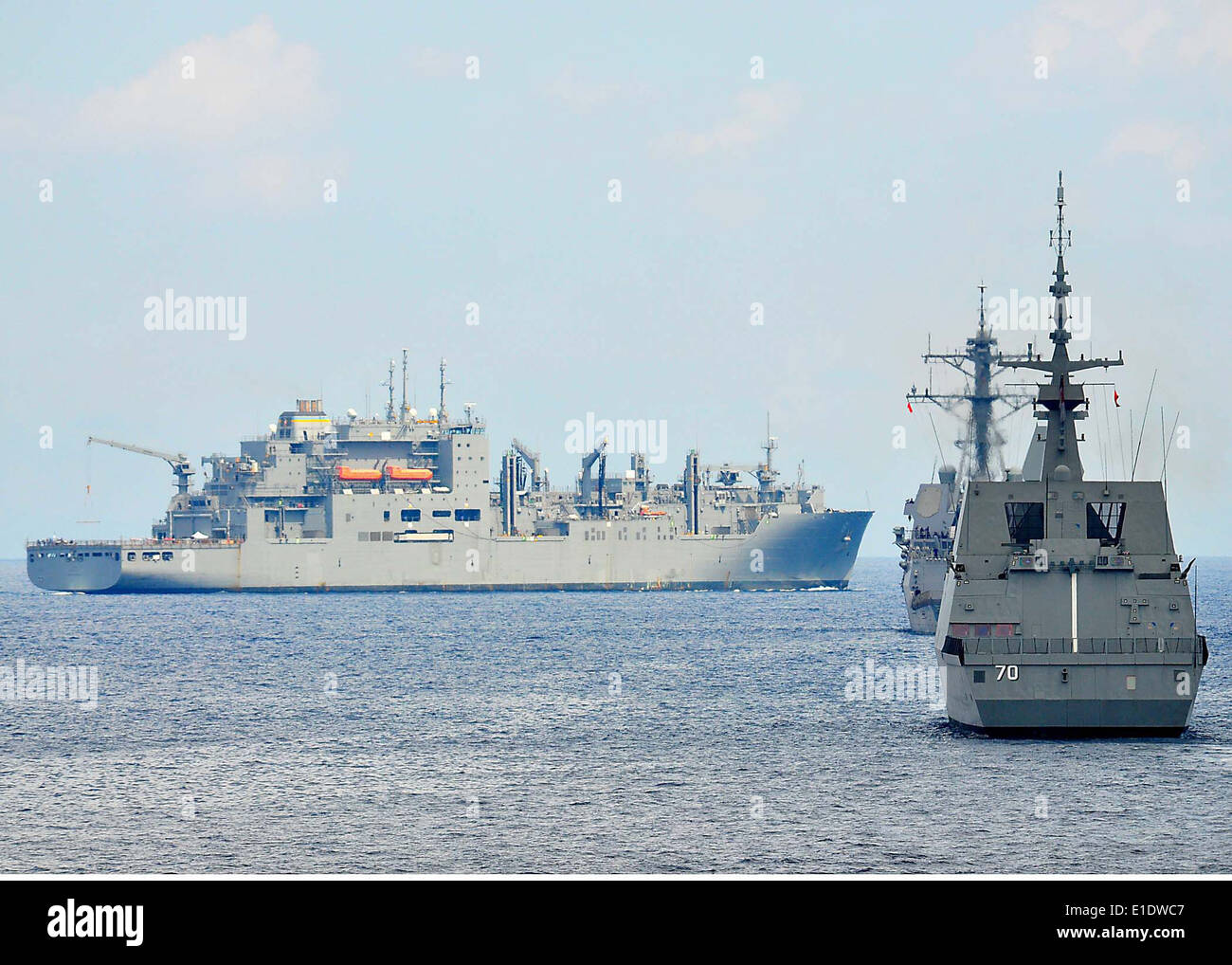 USNS Amelia Earhart (T-AKE 6) crosses the bow of the guided missile ...