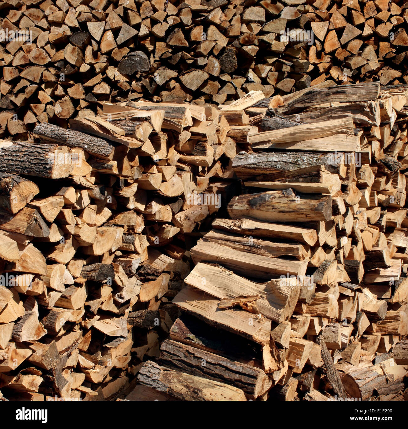 Chopped fire wood stacked in a pile as a symbol of country living using ...