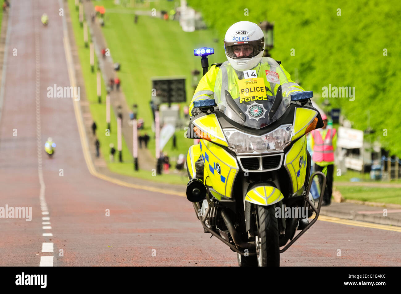 Two police motorcycle riders clear a long, straight and wide road of ...