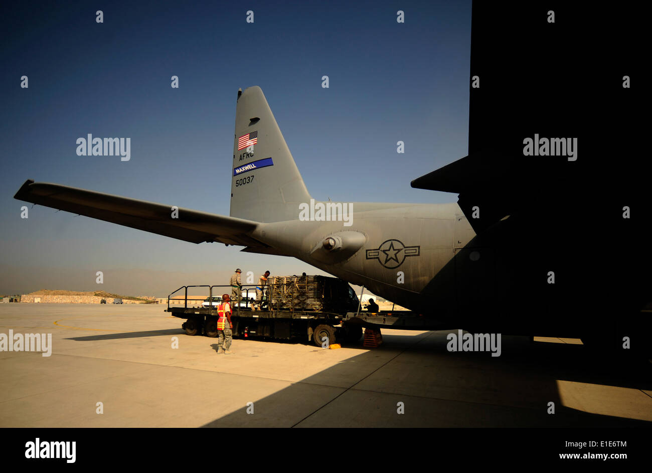 U.S. Airmen load aid and supplies onto a C-130H Hercules aircraft from ...