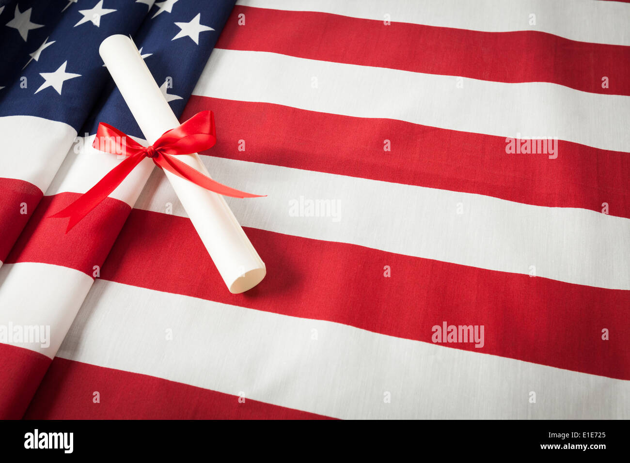 Red Ribbon Wrapped Diploma Resting on American Flag with Copy Space ...