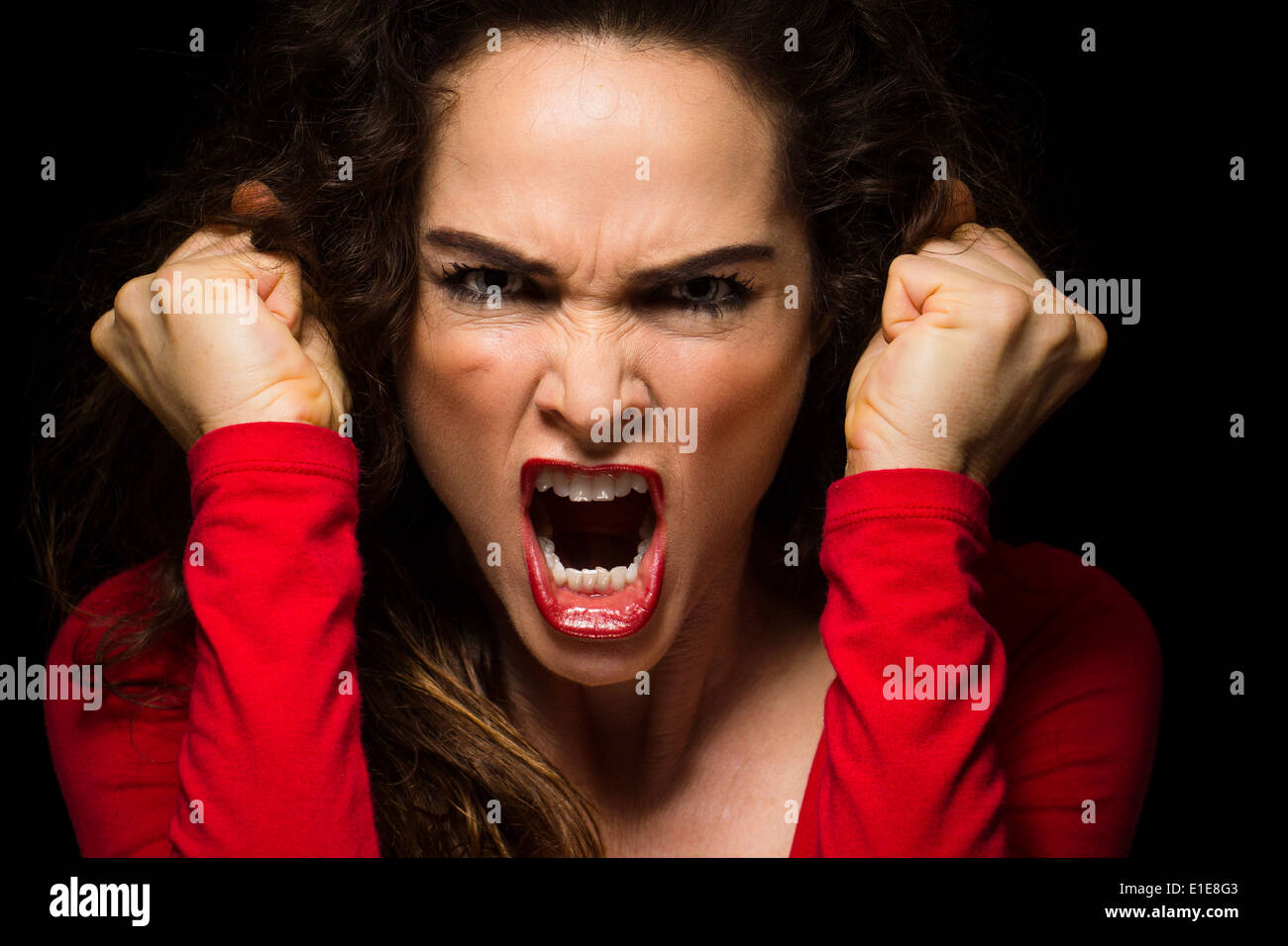 A very angry aggressive woman is clenching her fists in rage Stock ...