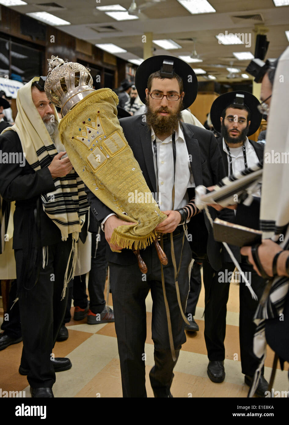 Religious Jewish men carry the Torah back to the holy ark during ...