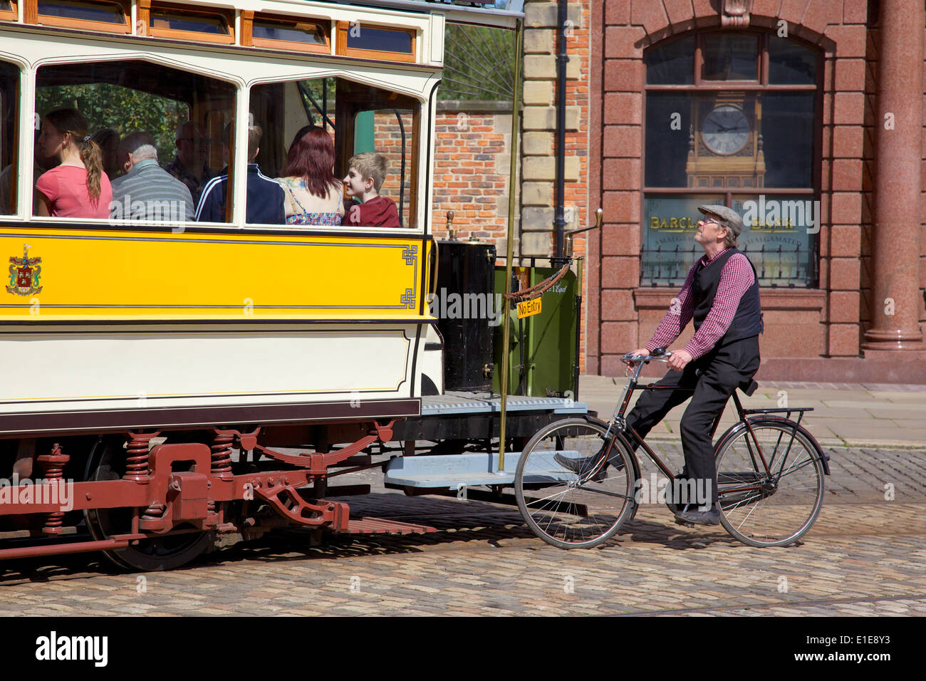 A cyclist inspects a tram in the high street of the Edwardian town that ...