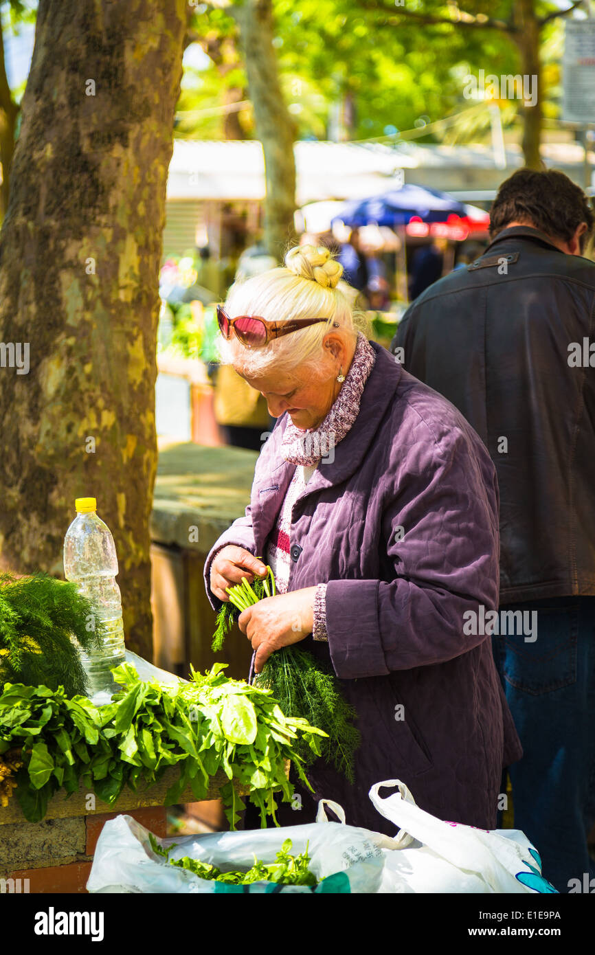 A Woman Prepares Fresh Vegetables To Sell From Her Stall At The Daily