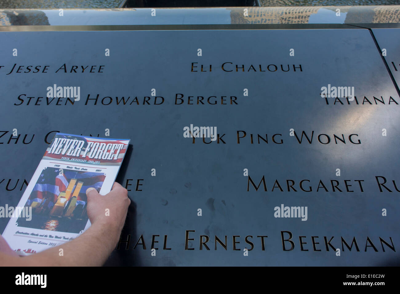 Detail of visitor's hand and names of victims at the 9/11 Memorial in ...