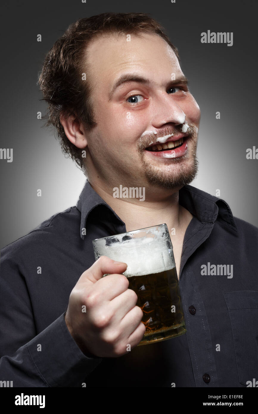 Smiling man with beer on a grey background. Studio photography Stock ...