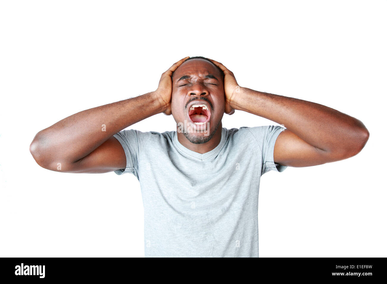 Portrait of african man shouting and closing ear by his hands on white ...