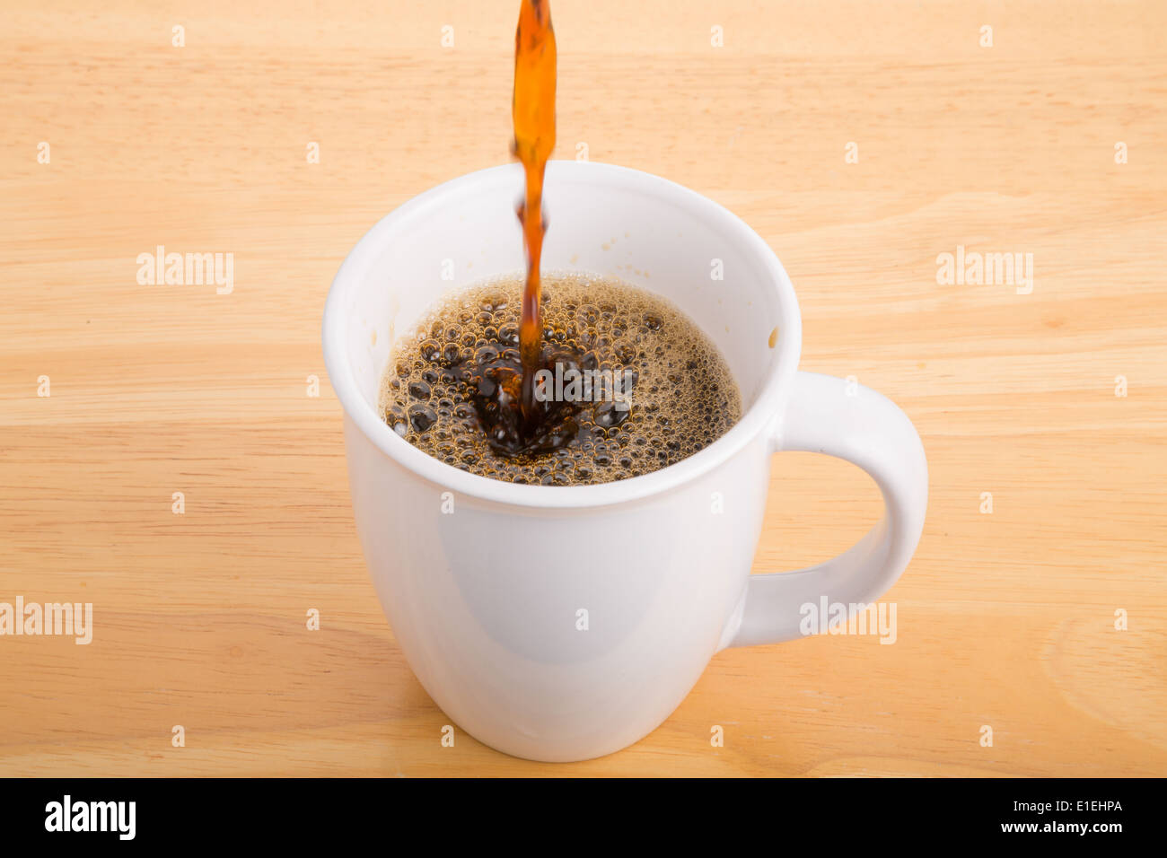 Pouring a cup of black coffee on a wood table Stock Photo - Alamy