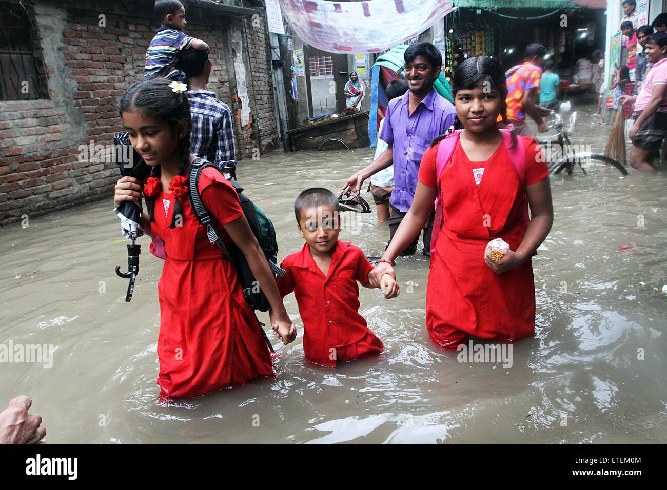 Students go to school through the knee deep water at City’s Dhanmondi ...