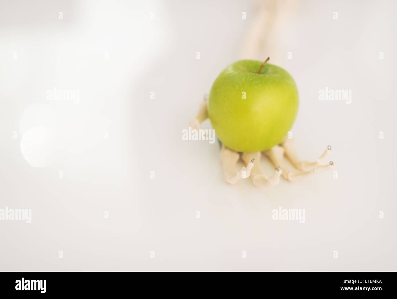 Closeup on human skeleton hand holding apple Stock Photo - Alamy