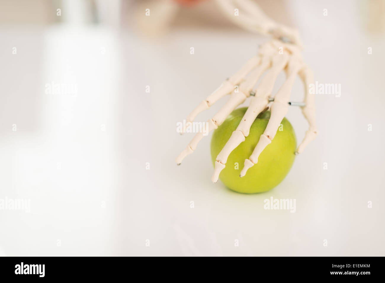 Closeup on human skeleton hand holding apple Stock Photo - Alamy