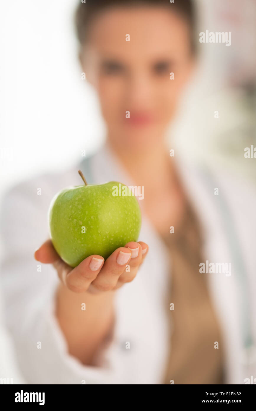 Closeup on medical doctor woman giving apple Stock Photo - Alamy