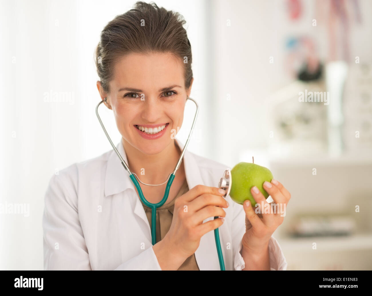 Happy medical doctor woman examining apple with stethoscope Stock Photo ...