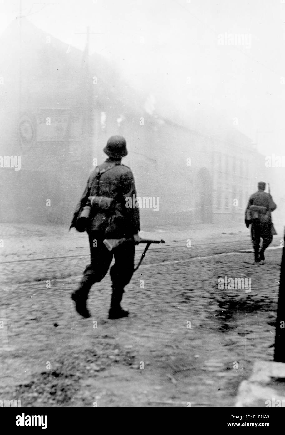 German soldiers march through a German city which was attacked by ...