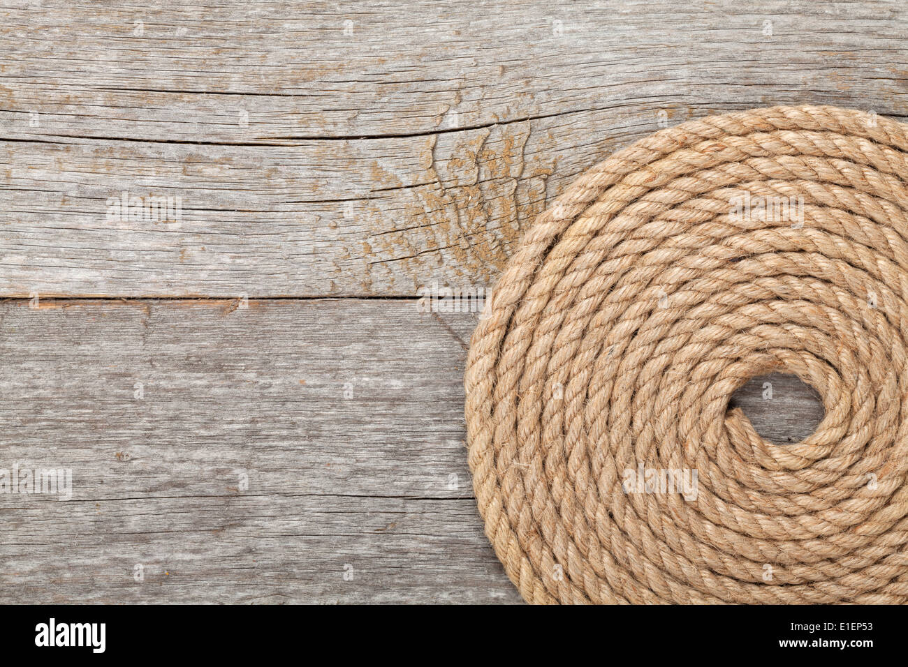 Roll of ship rope on wooden texture background Stock Photo - Alamy