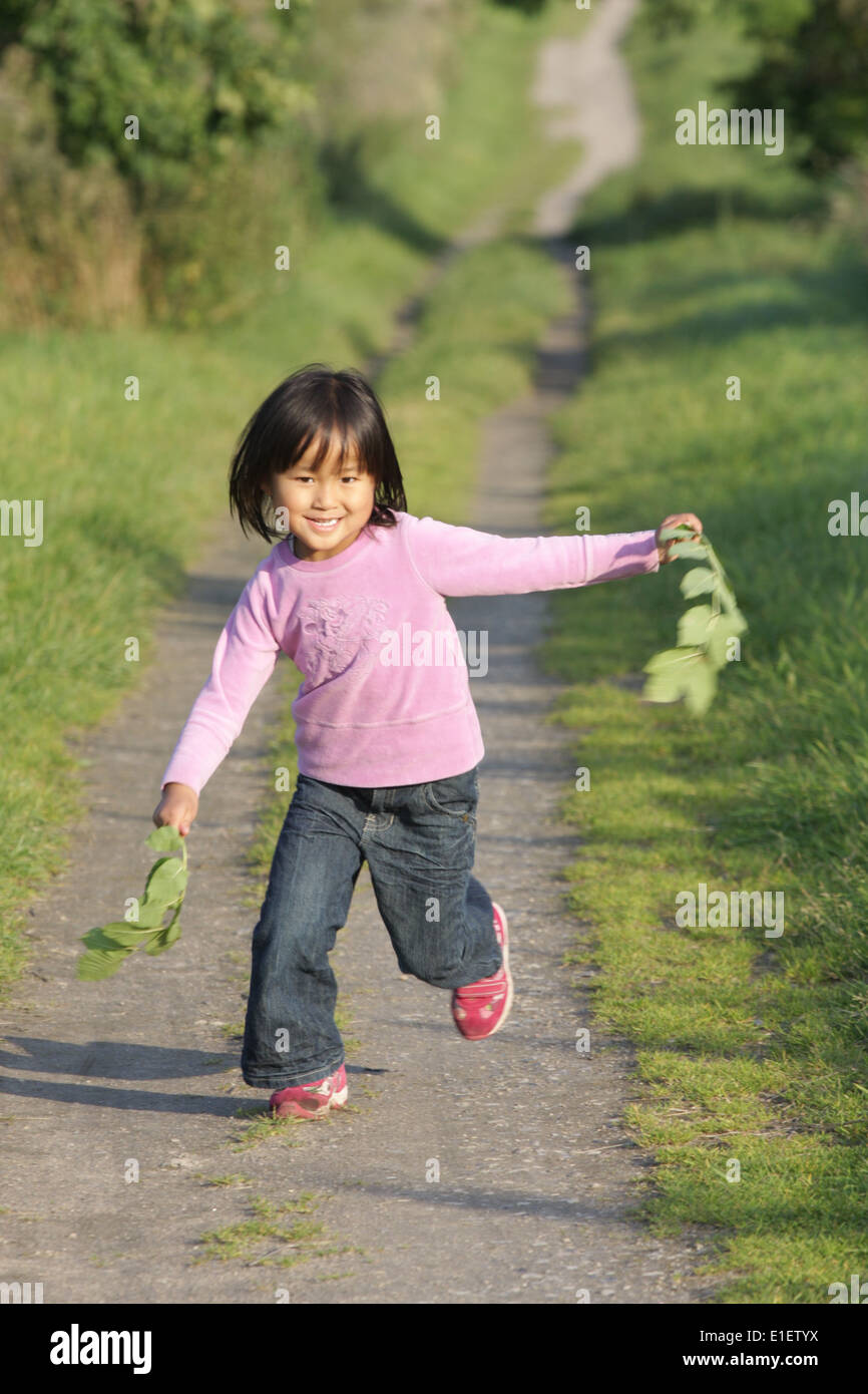 child outdoor in a forest path running with tree leaves Stock Photo - Alamy