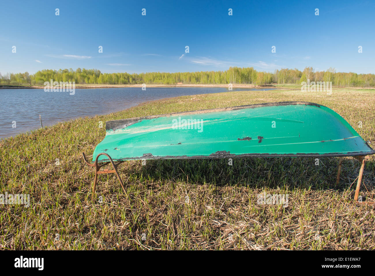 Blue rowing Boat resting ashore Stock Photo - Alamy