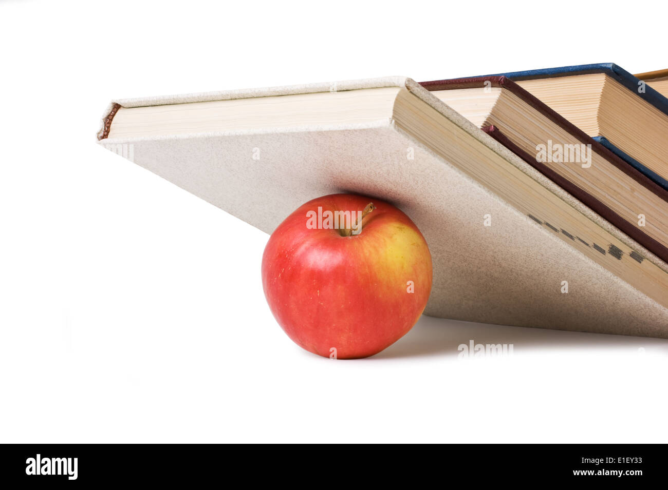 apple under a pile of books isolated on white Stock Photo - Alamy