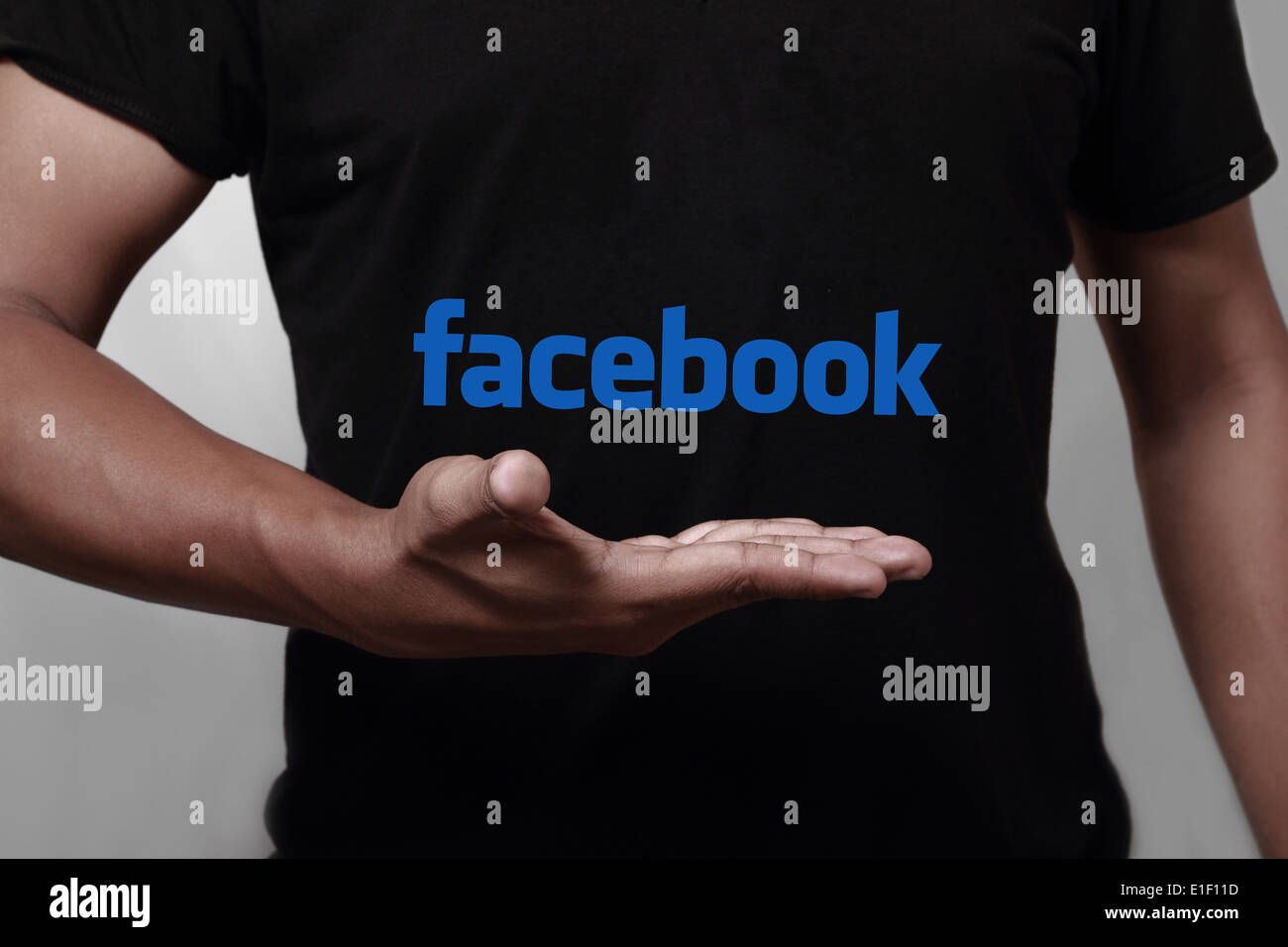 Hand showing facebook icon. Facebook is a largest social networking ...