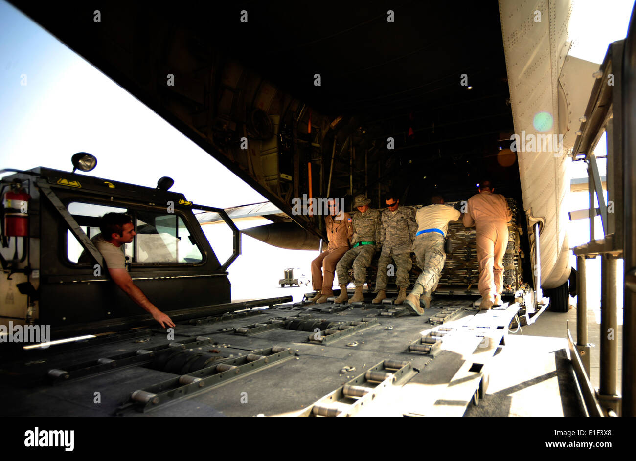 U.S. Airmen load aid and supplies onto a C-130H Hercules aircraft from ...