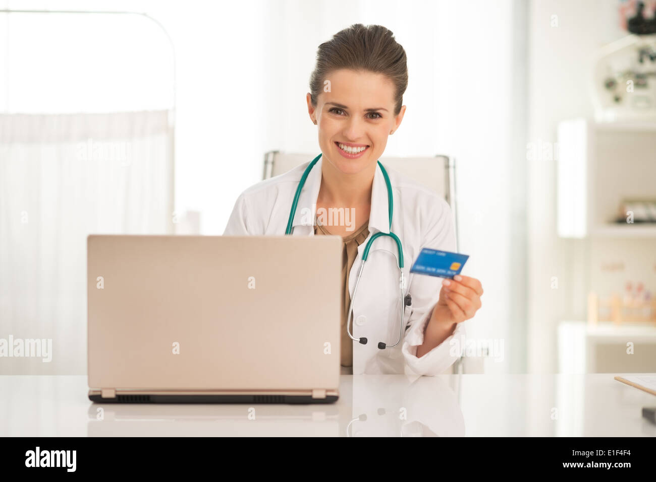 Medical doctor woman with credit card and laptop Stock Photo - Alamy