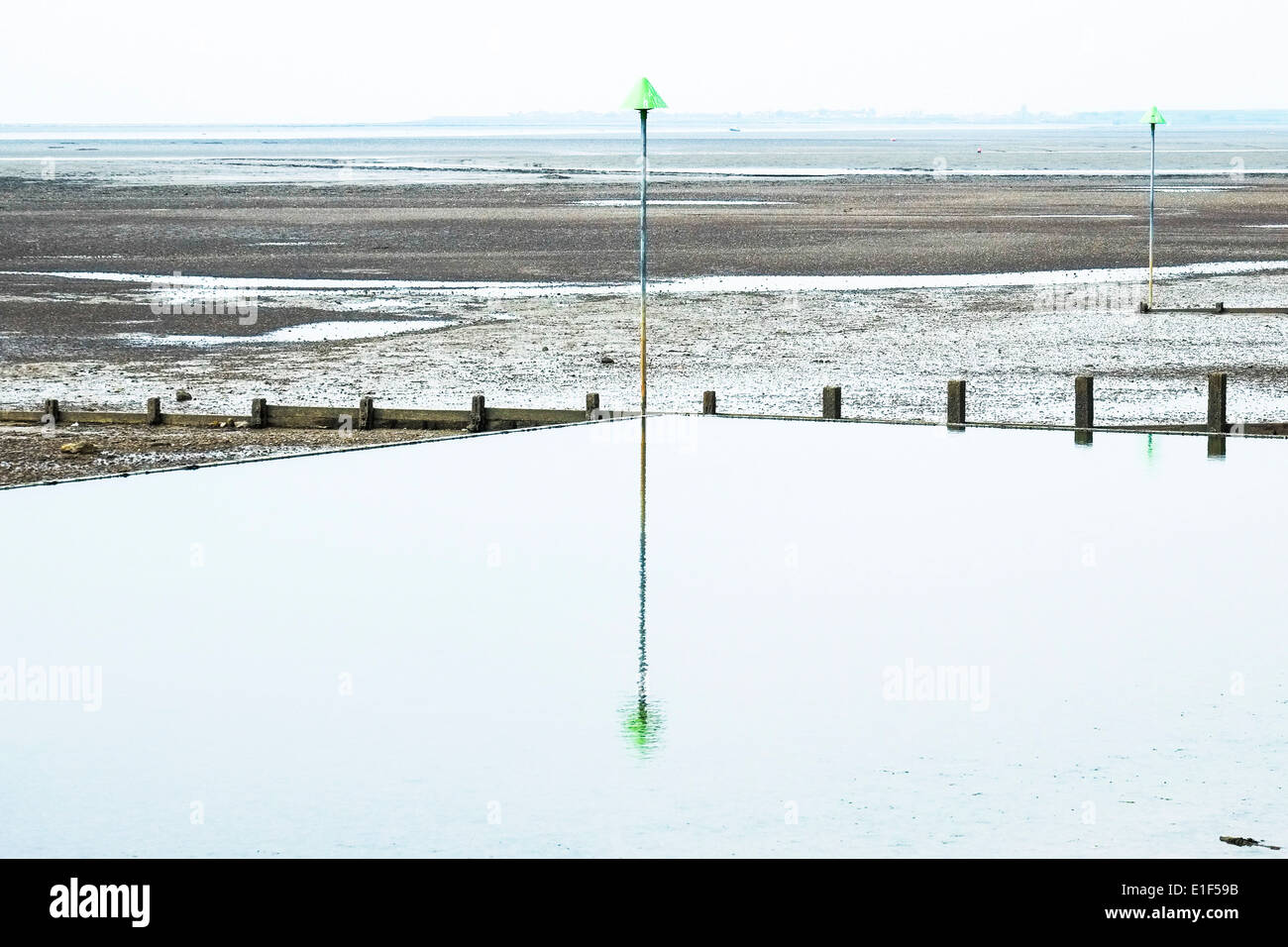 A warning pole reflected in the water of a paddling pool at Southend on ...
